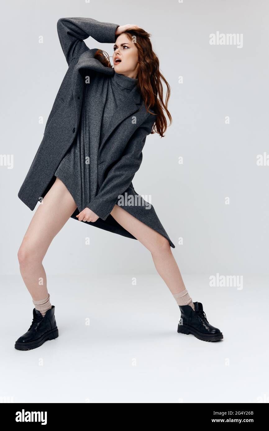 aggressive style woman in boots sweater coat hairstyle Stock Photo - Alamy