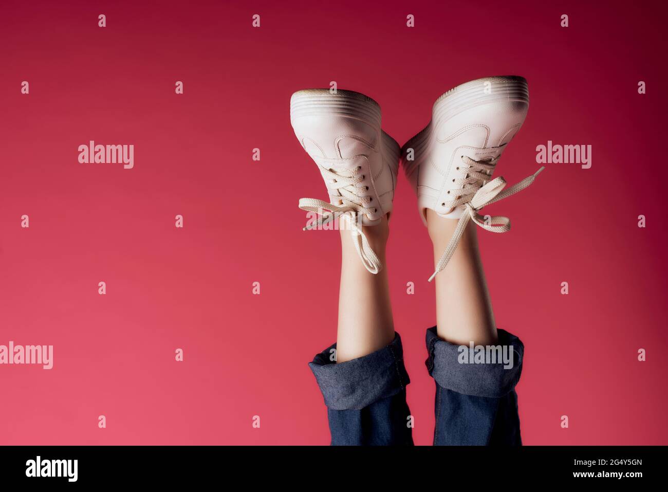 inverted female legs in white sneakers modern style isolated background ...