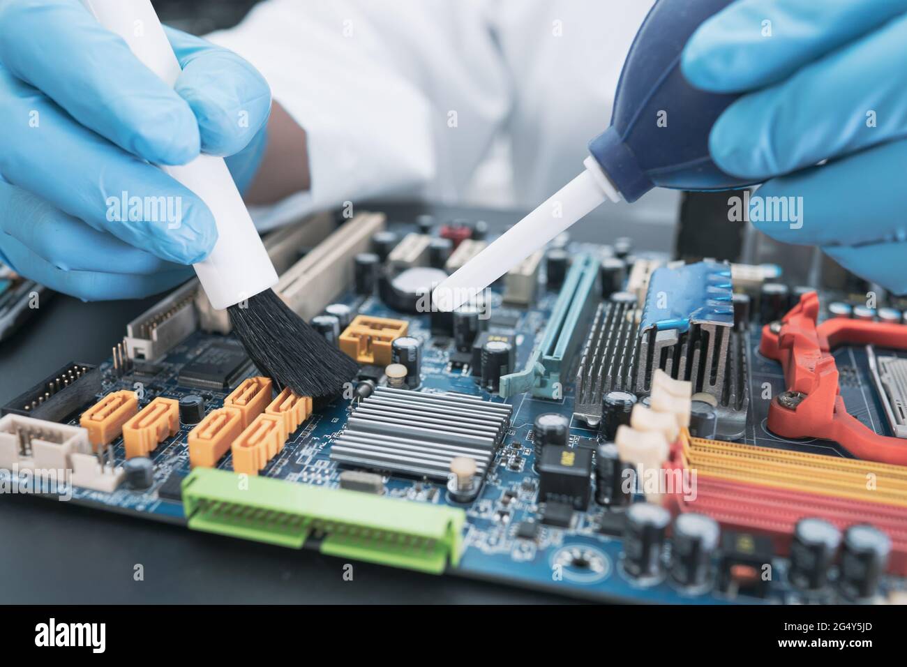 Technician use brush and air blower ball to clean dust in circuit board ...