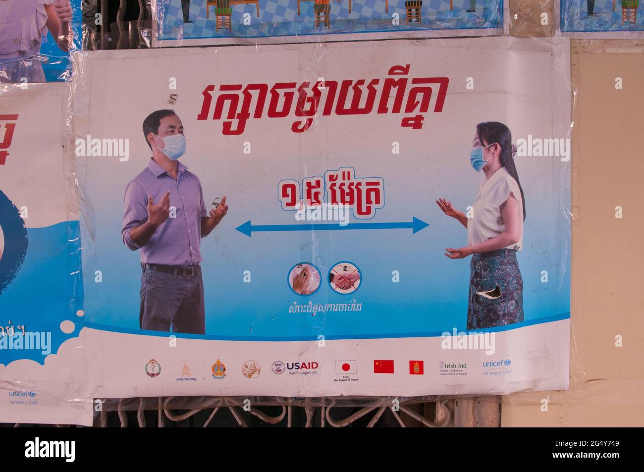 during an outbreak of COVID - 19, USAID puts up posters in Khmer script ...