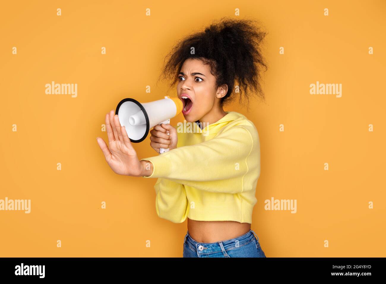 Girl shouts in megaphone and shows stop gesture. Photo of african ...