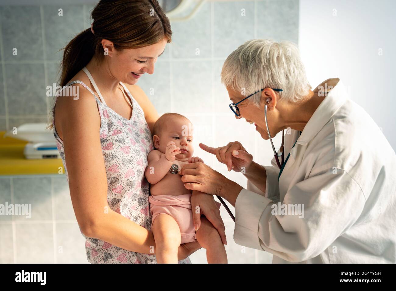 Happy pediatrician doctor with baby checking possible heart defect ...