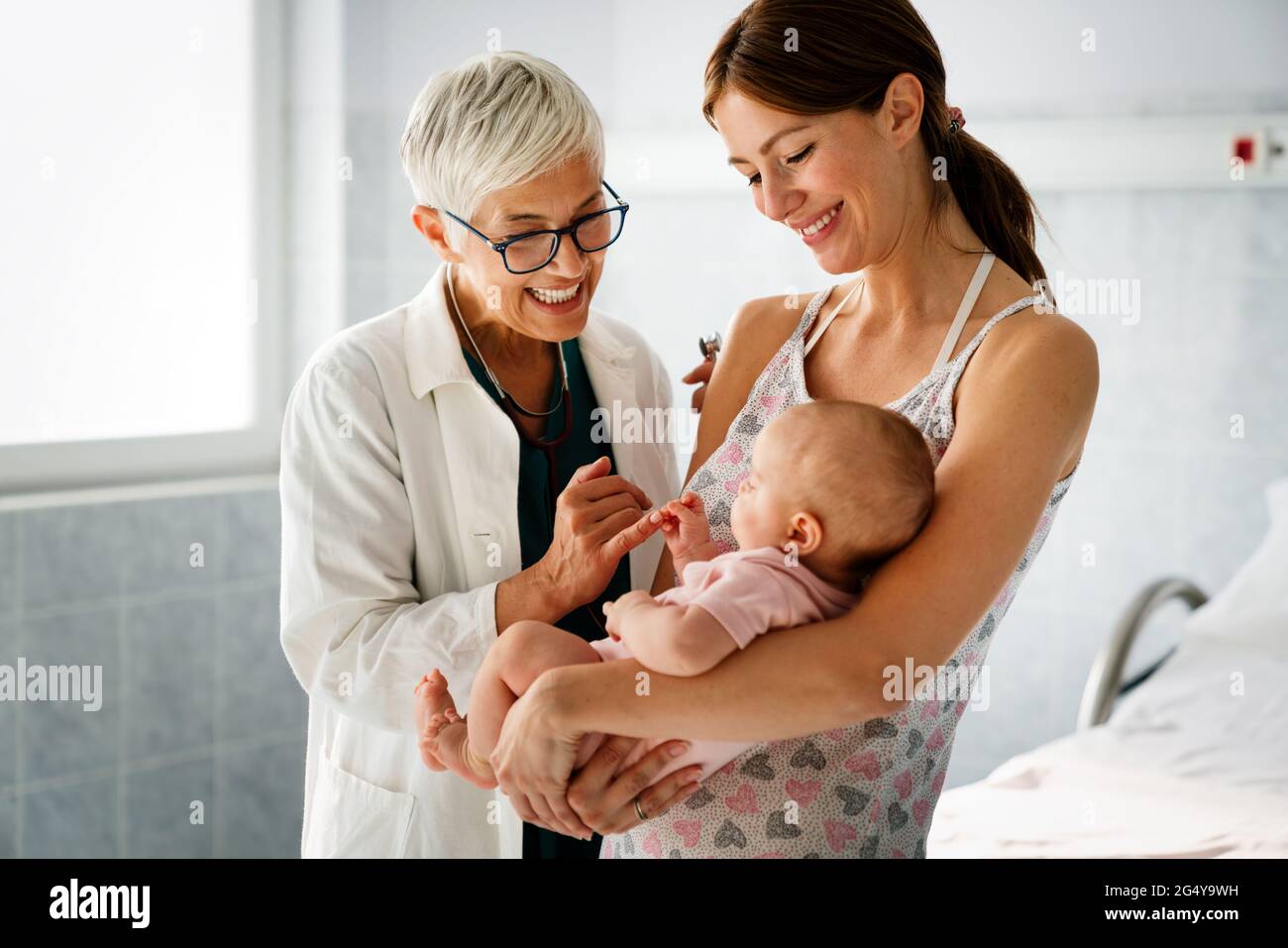 Happy pediatrician doctor with baby checking possible heart defect ...