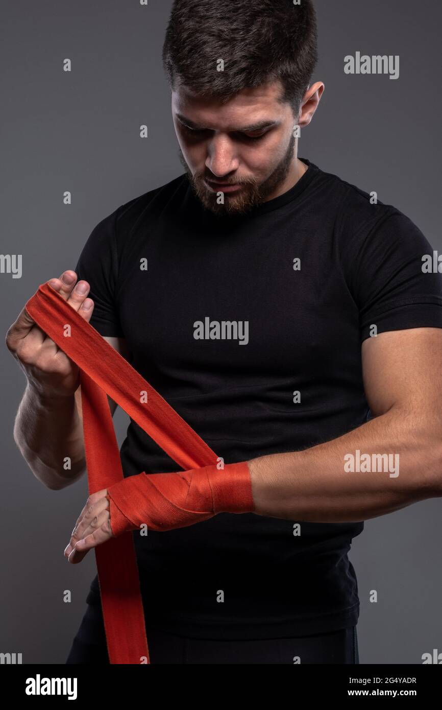 Young man wrapping wrists with red boxing tape Stock Photo - Alamy