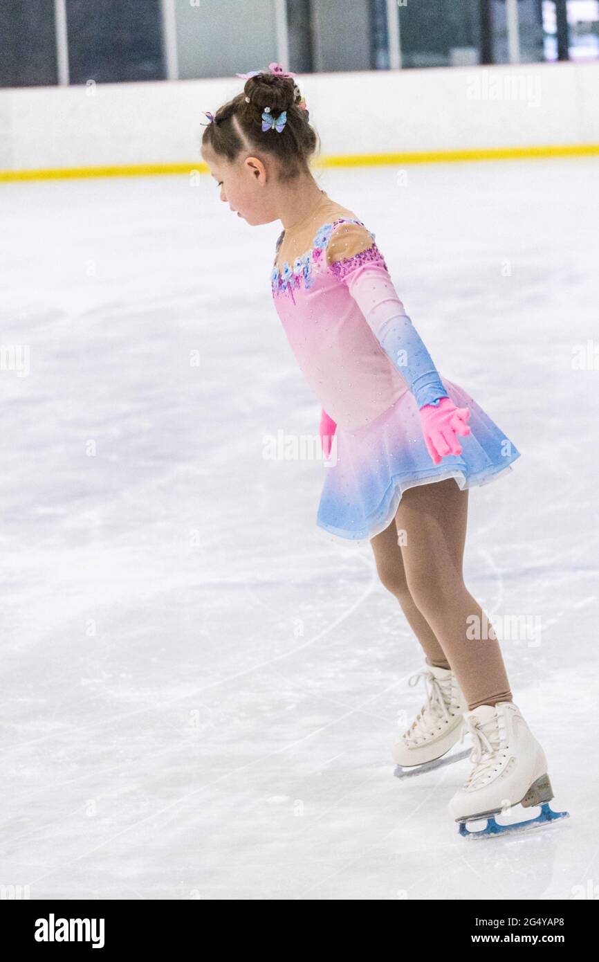 Little girl practicing figure skating on an indoor ice rink Stock Photo ...