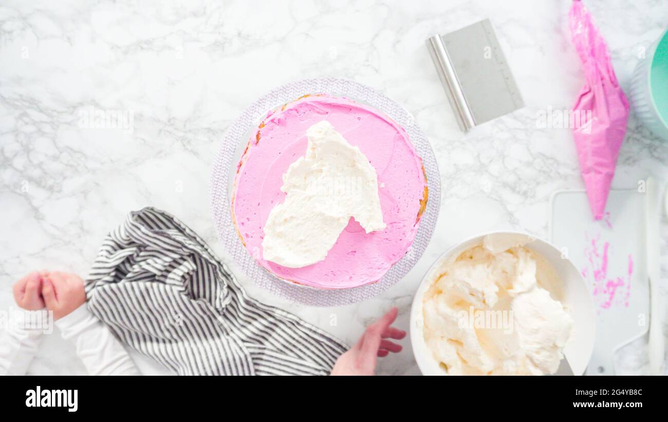 Flat lay. Step by step. Frosting round funfetti cake with white italian ...