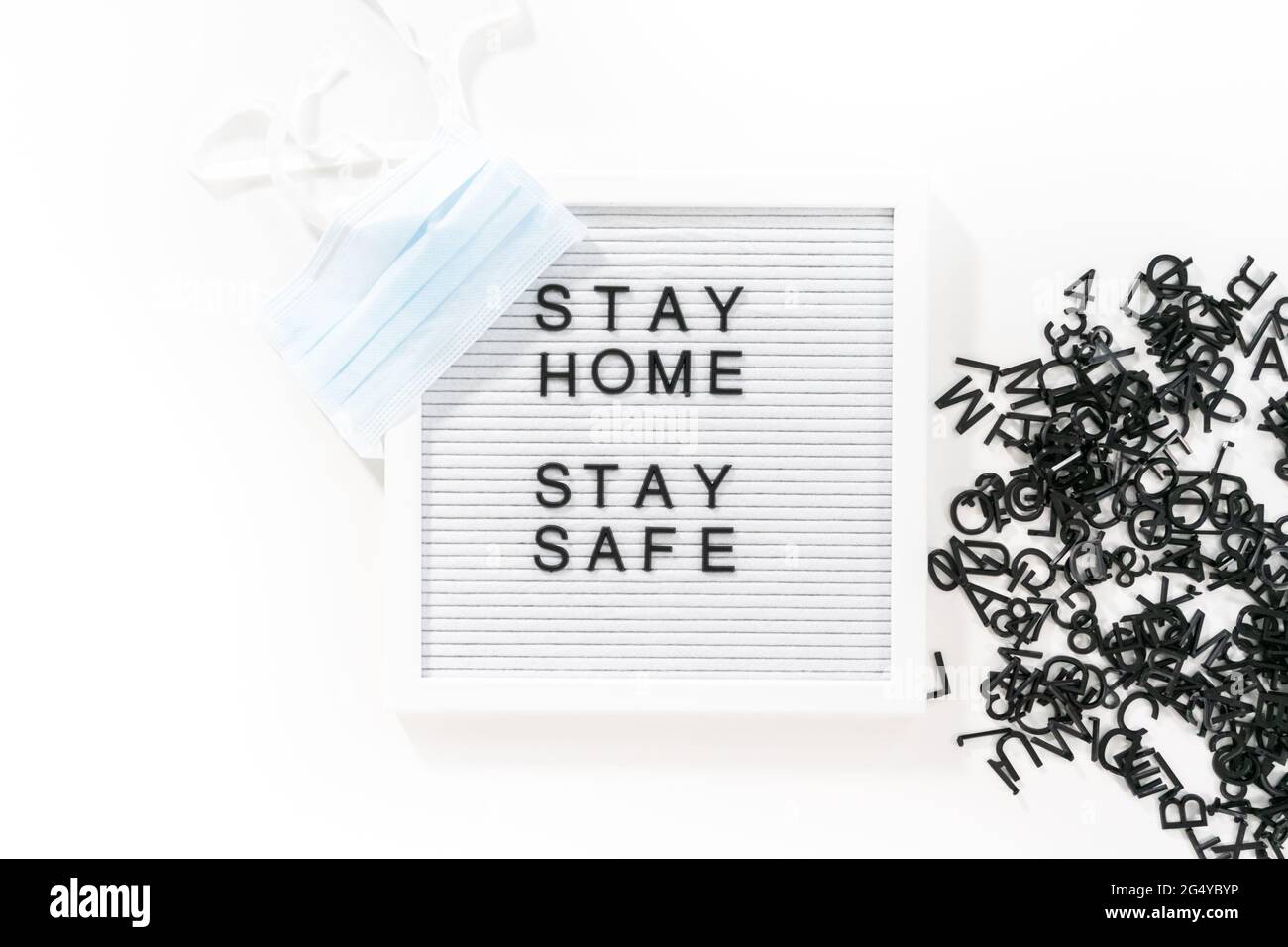 STAY HOME and STAY SAFE sign on message board with a blue medical mask ...