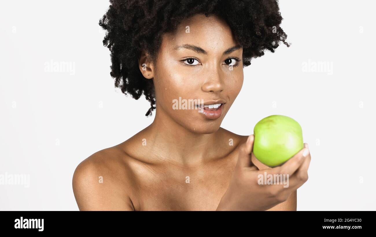 Pretty african american woman with clean face holding green apple ...