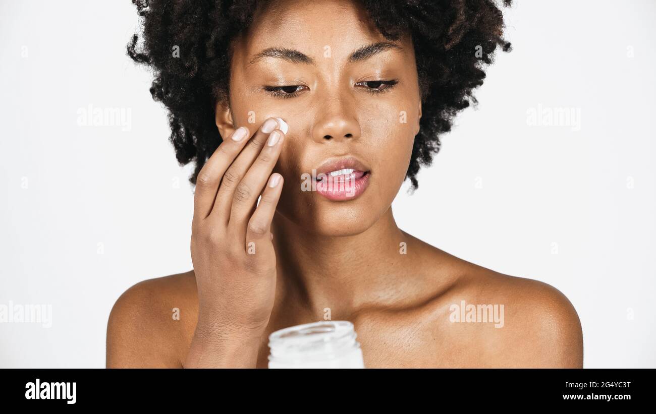 African american woman with perfect skin applying cosmetic cream on ...