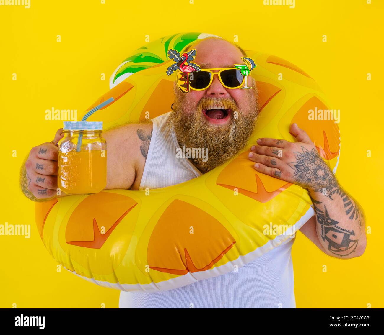 Fat happy man with wig in head is ready to swim with a donut lifesaver ...