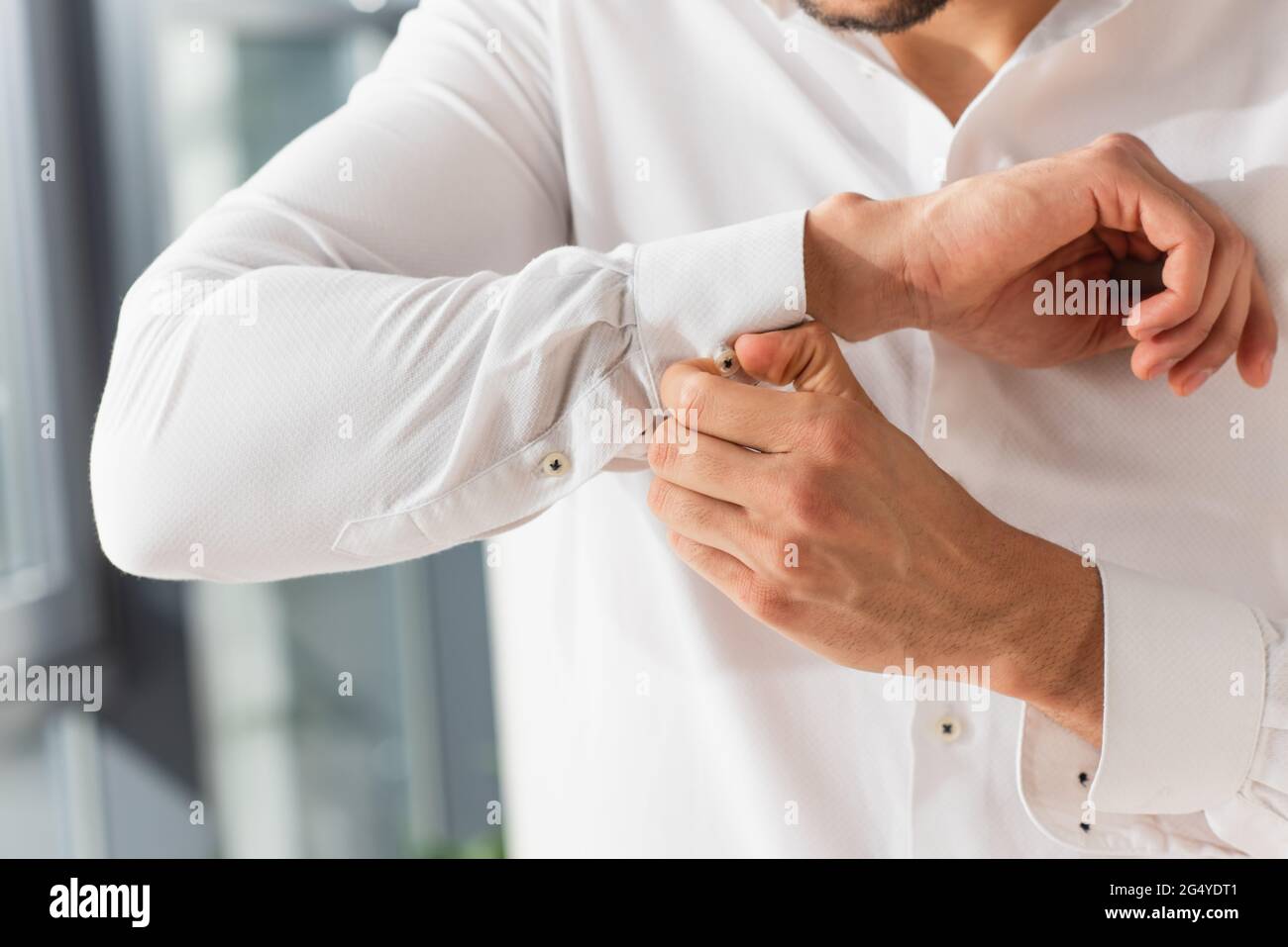 Buttoning his shirt sleeve hi-res stock photography and images - Alamy