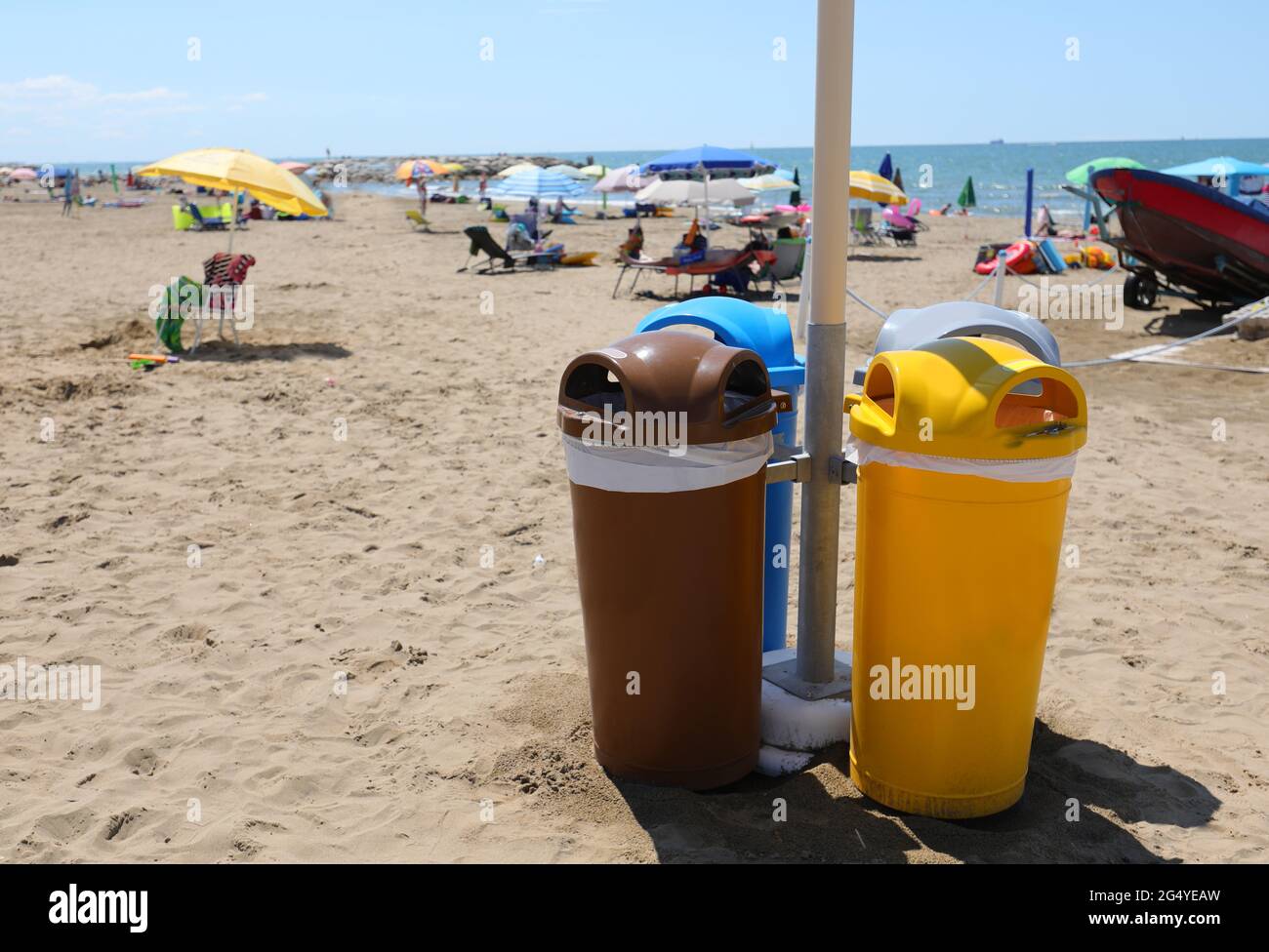 colorful bins for separate waste collection on the beach by the sea in ...