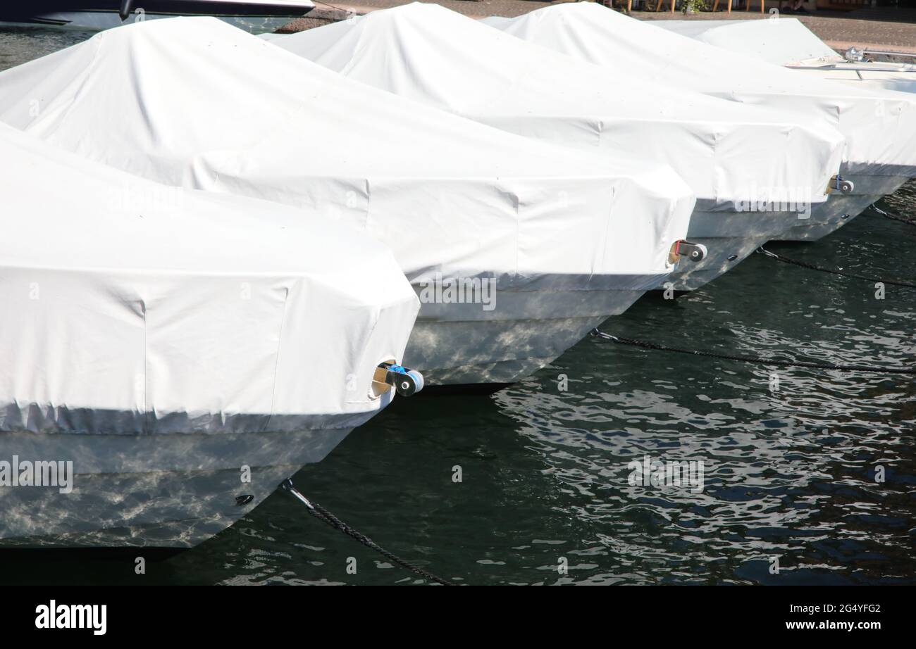 covered boats with plastic tarpaulins for protection from the weather ...