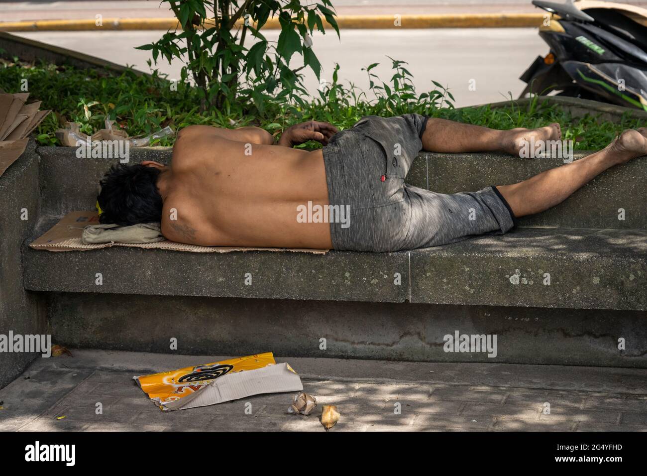 A homeless person finds rest on a park bench in Iquitos, Peru Stock ...