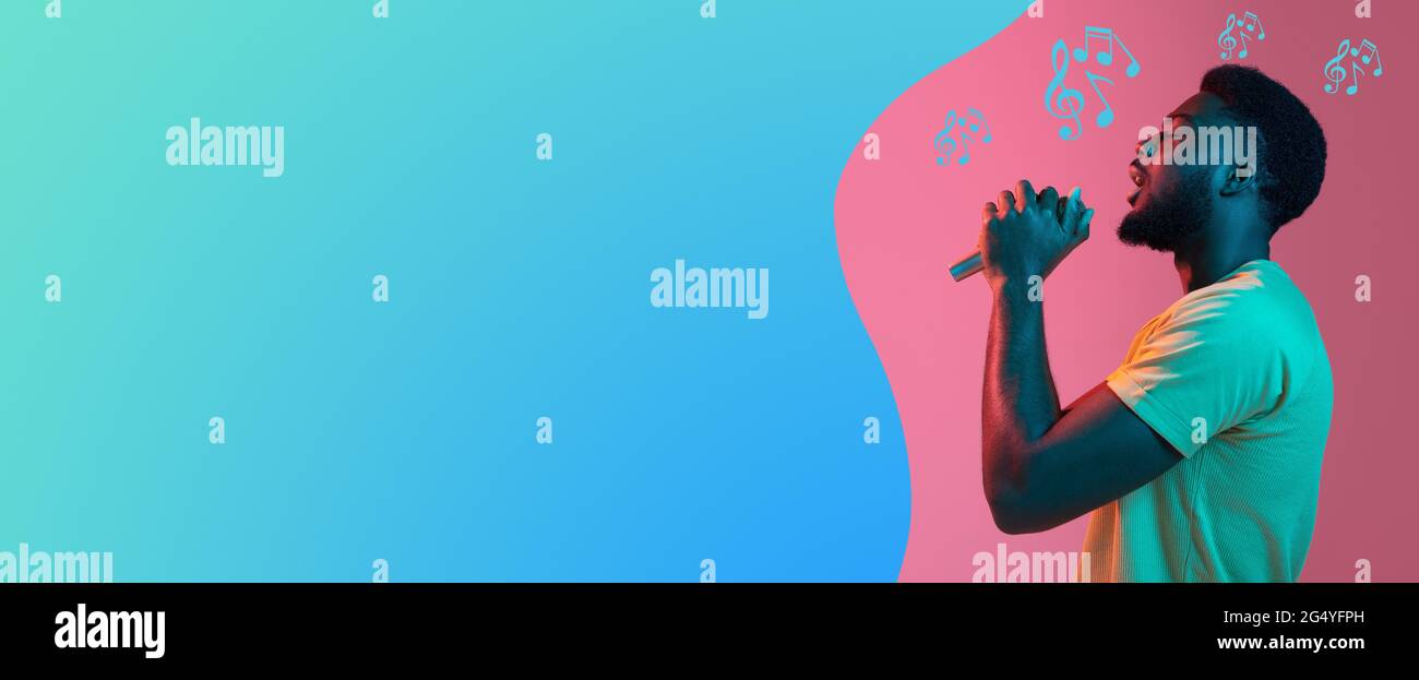 Portrait of young man, singer isolated on blue pink background in ...