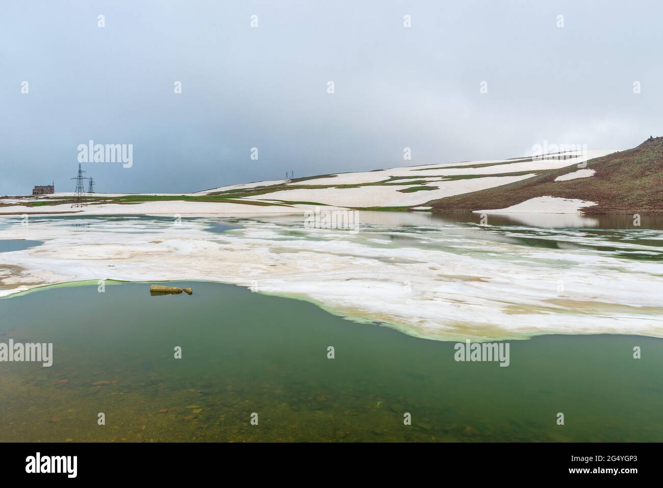 Kari lake in the mountains of Armenia covered in snow in June Stock ...