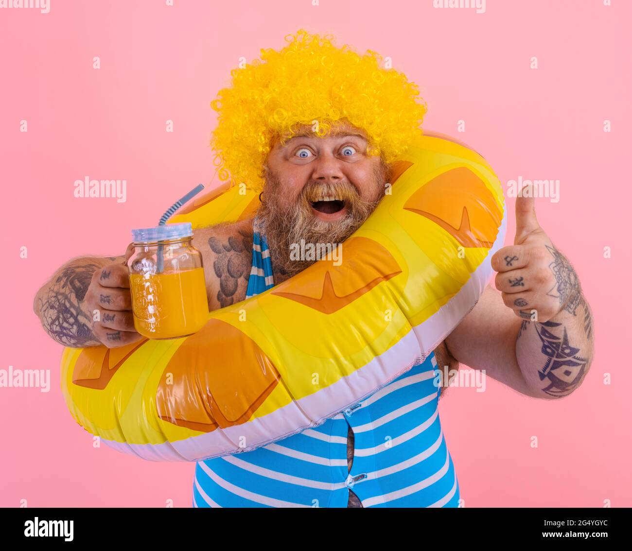 Fat happy man with wig in head is ready to swim with a donut lifesaver ...