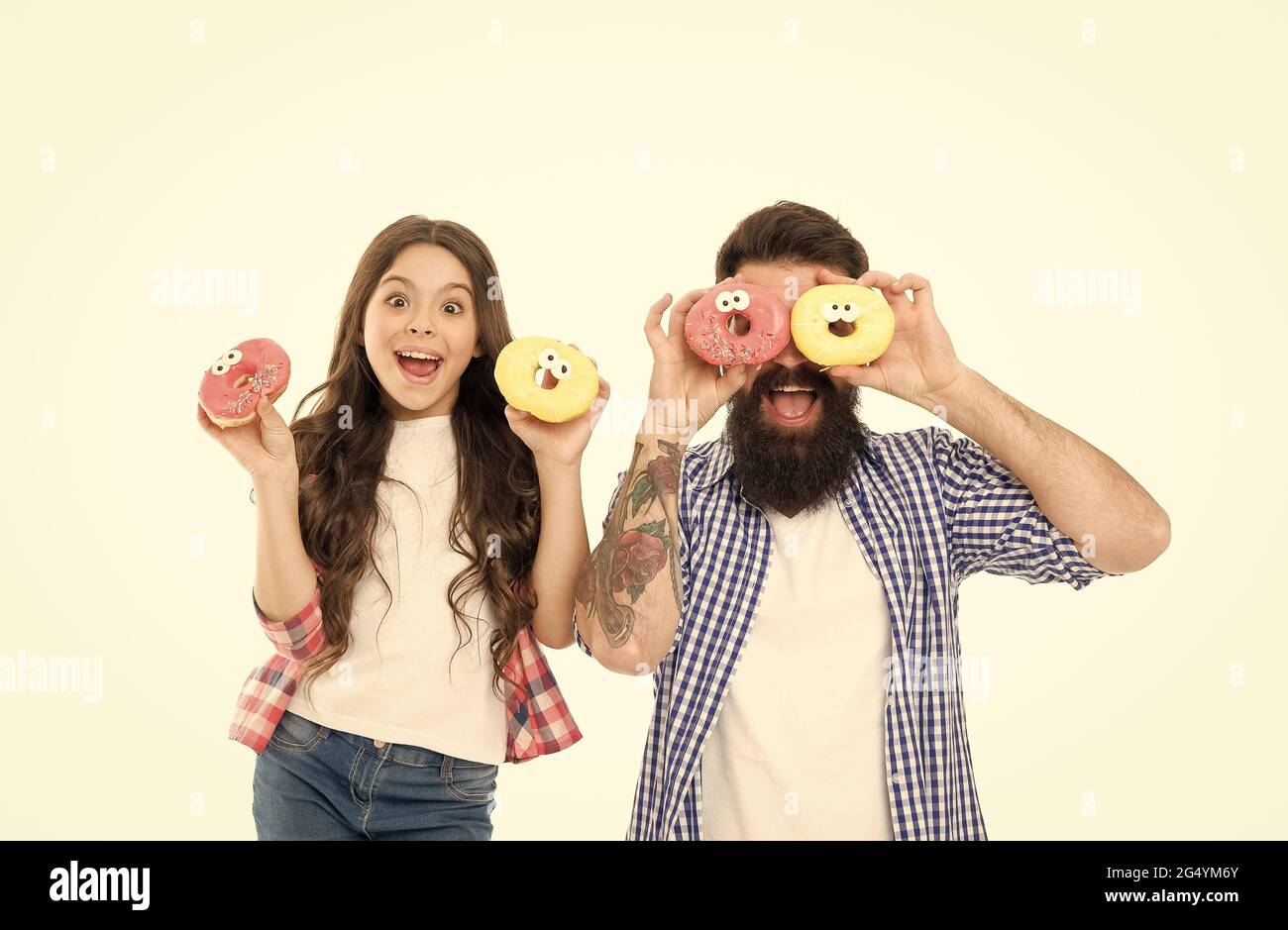 Sweets and treats concept. Daughter and father eat sweet donuts ...