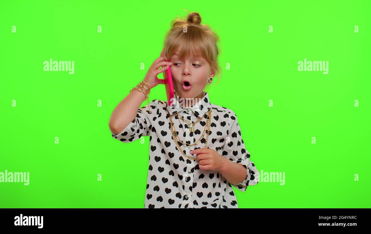 Stylish playful child girl looking at camera doing phone gesture like ...