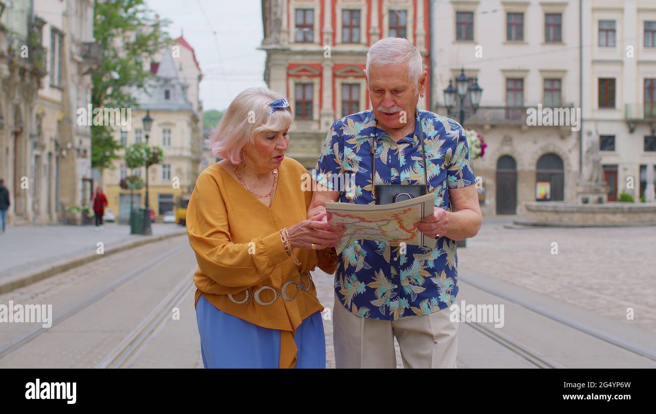 Senior grandmother and grandfather tourists looking for a place to go ...