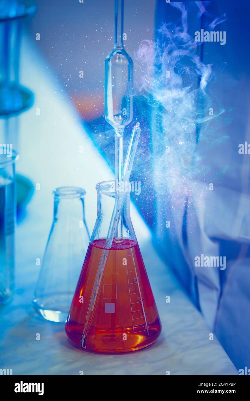 Glass laboratory flasks with chemical substance and magic glow. Making ...