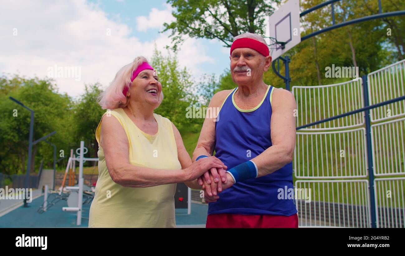 Active senior sports team athletes putting arms hands together ...