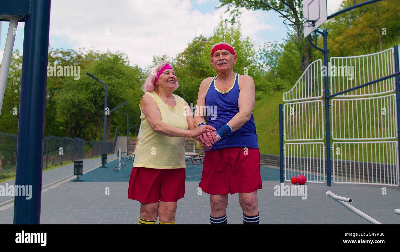 Active senior sports team athletes putting arms hands together ...