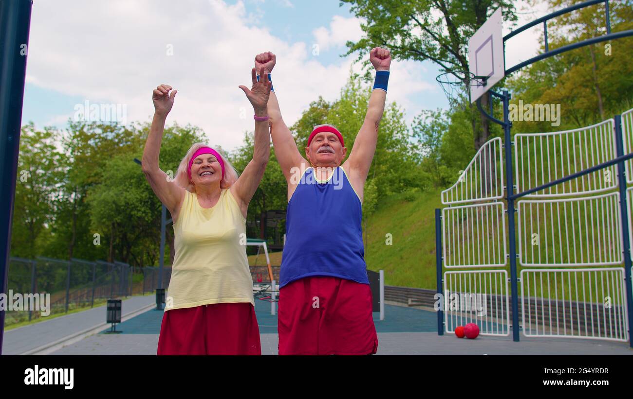 Active senior sports team athletes rising arms hands together, cheering ...