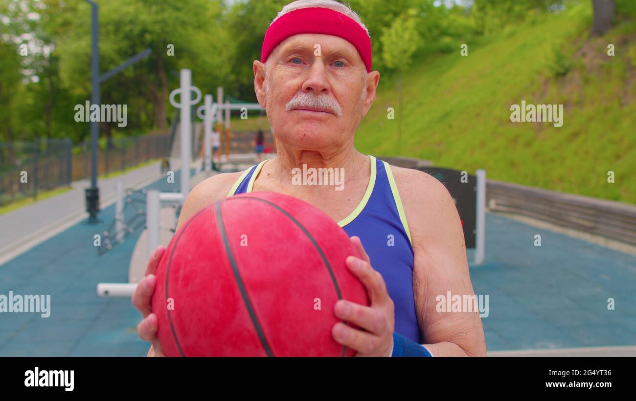 Senior old man grandfather athlete posing playing with ball outdoors on ...