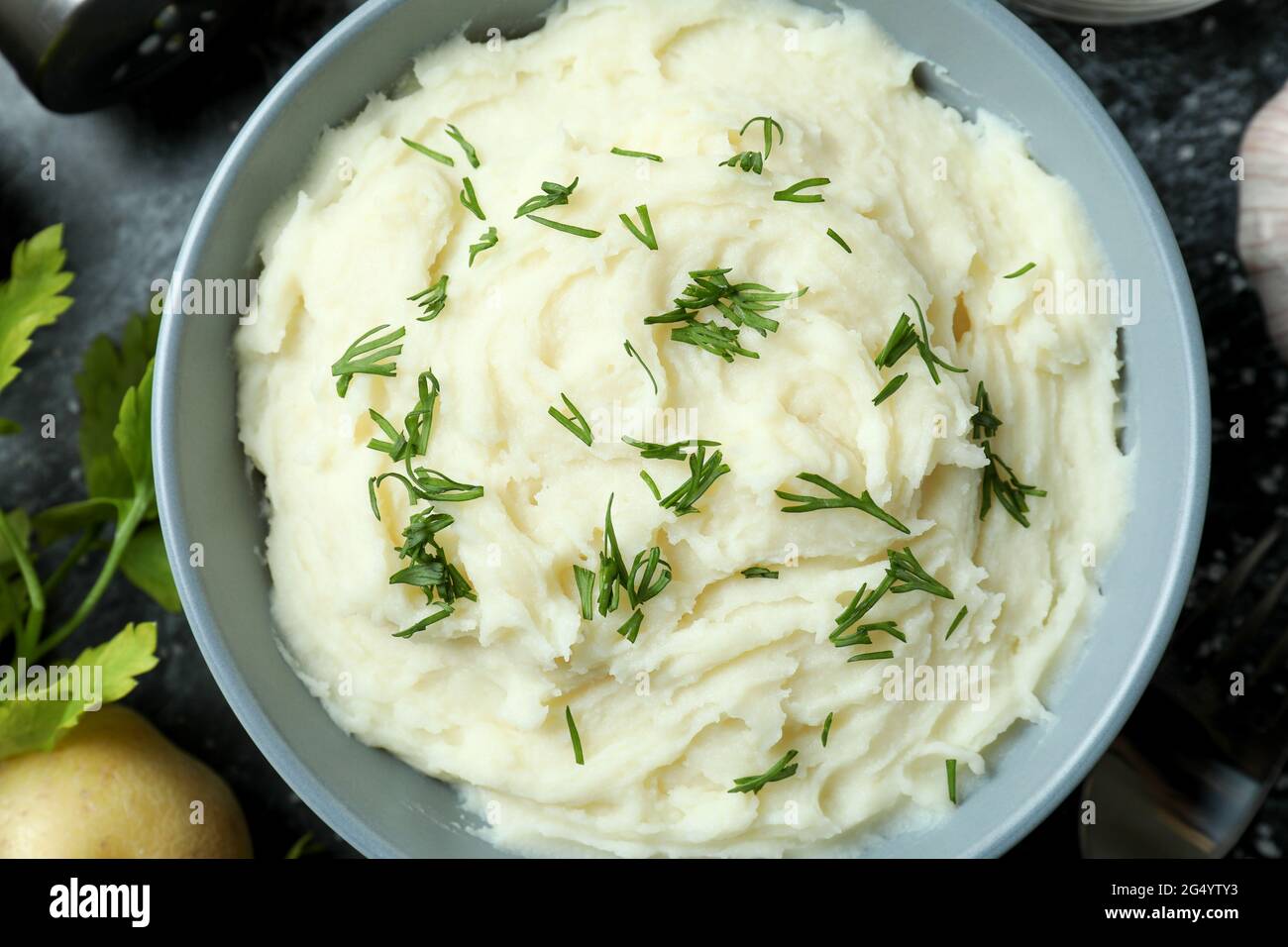 Concept of tasty eating with mashed potatoes on black smokey table ...