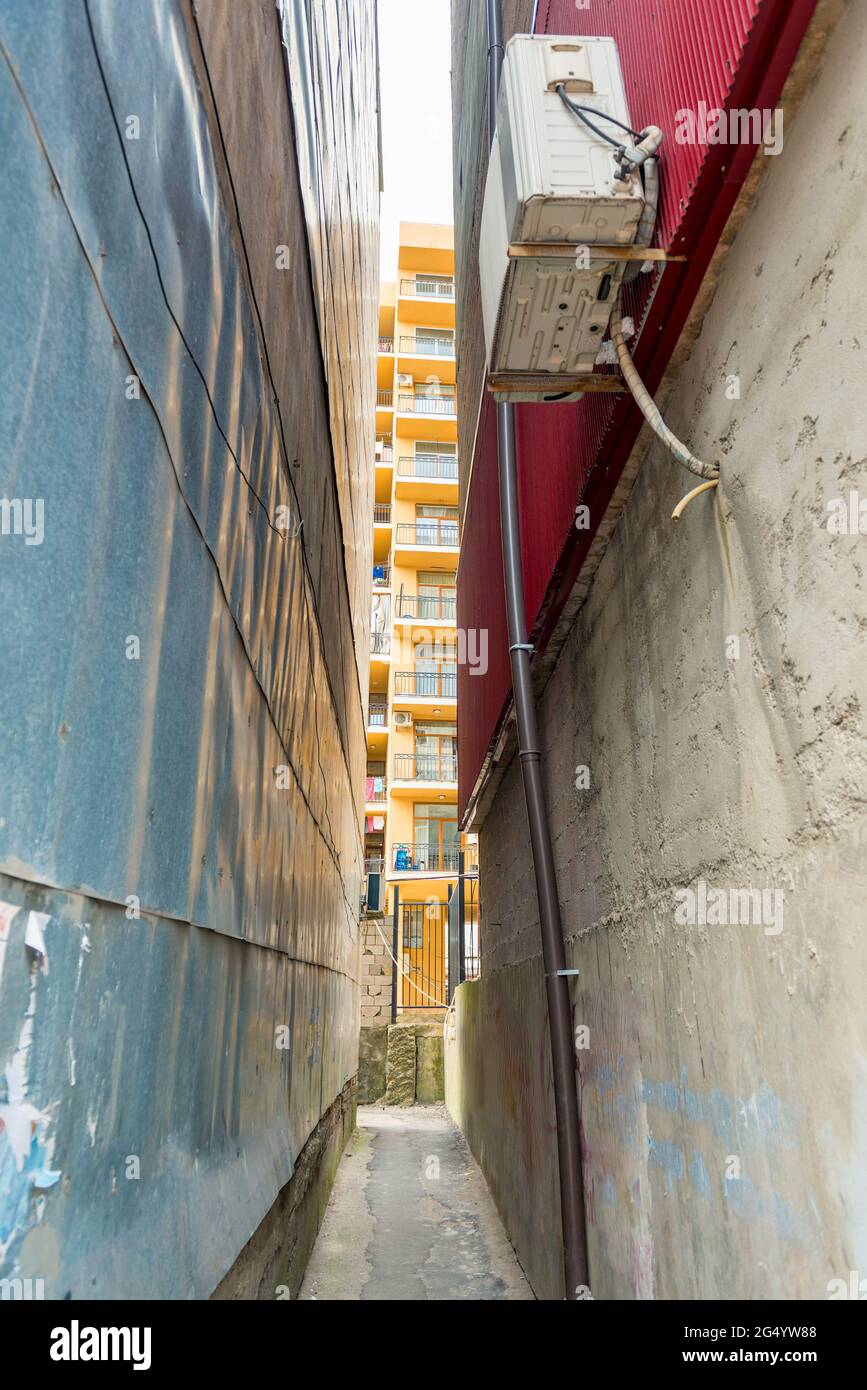 narrow passage between houses and a view of the house with balconies ...