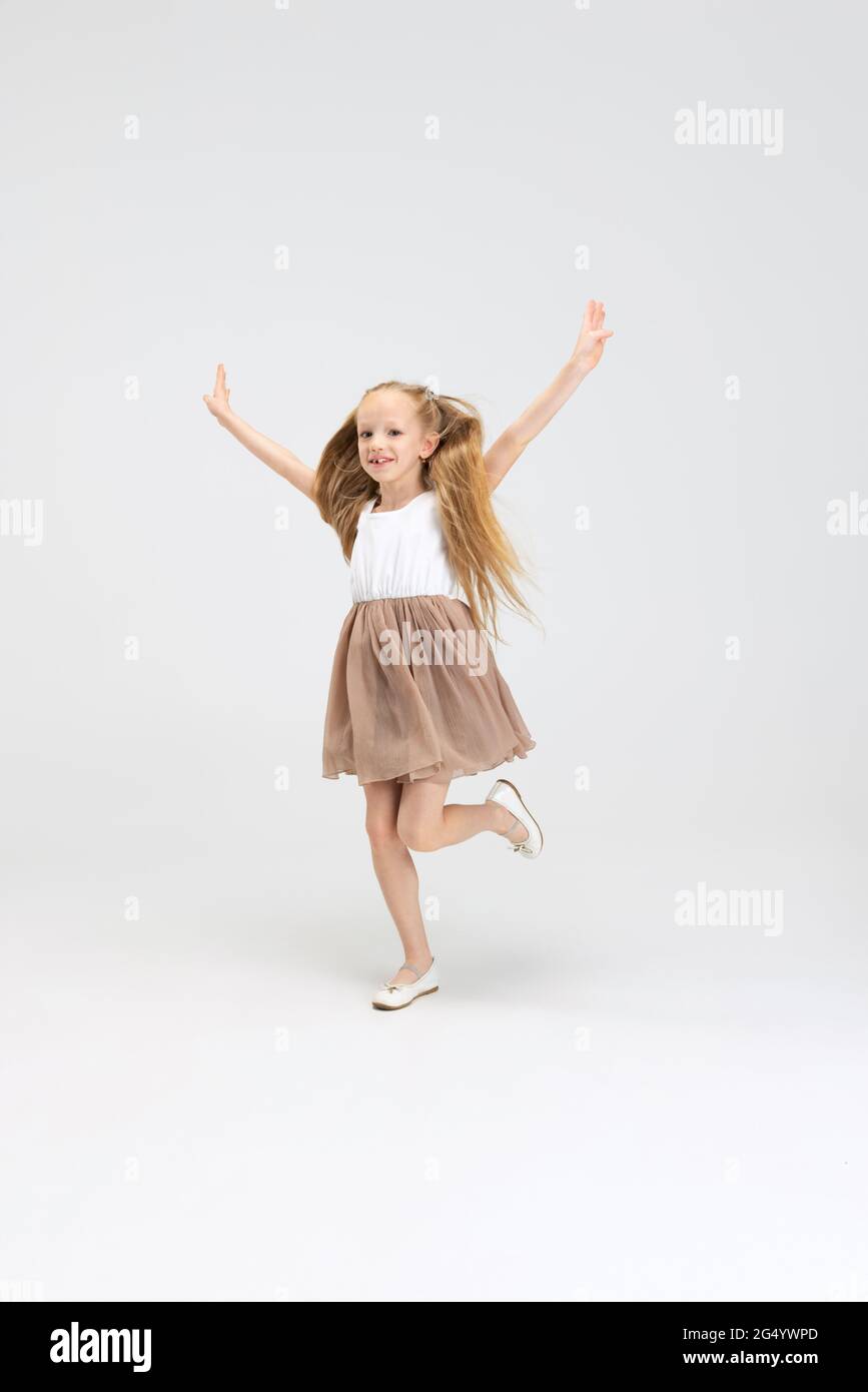 Beautiful little girl in modern stylish dress posing isolated on white ...