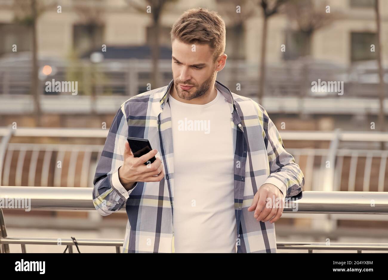 Your true companion. Handsome man use phone outdoors. Online chatting ...