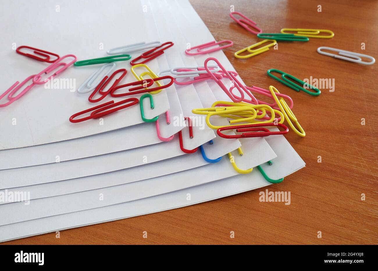 Paper sheets with colored paper clips on desktop Stock Photo - Alamy