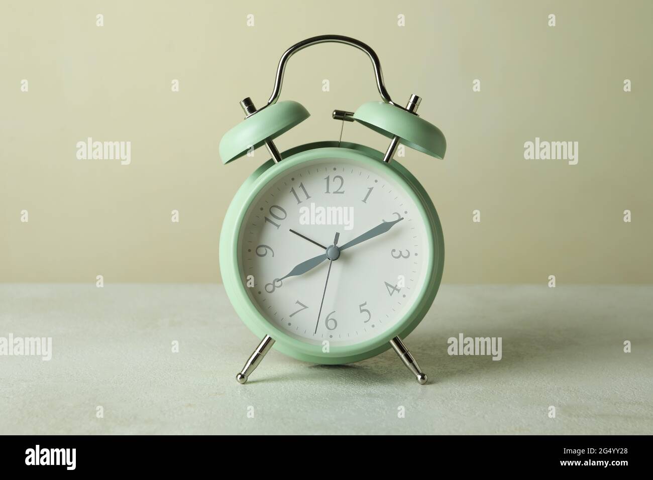 Stylish mint alarm clock against beige background Stock Photo - Alamy