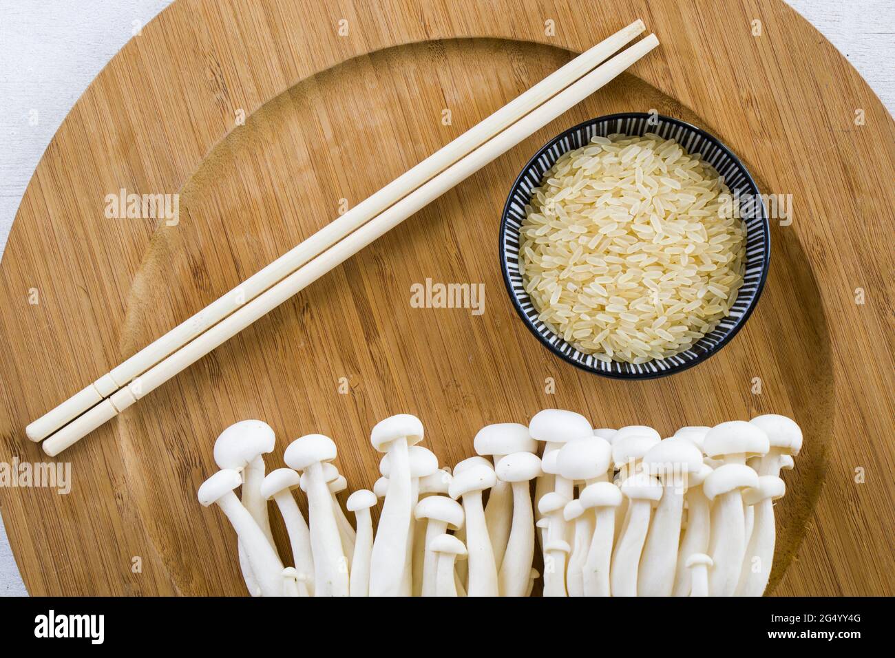 Top view of white Asian Enoki mushroom and rice served on a wooden ...