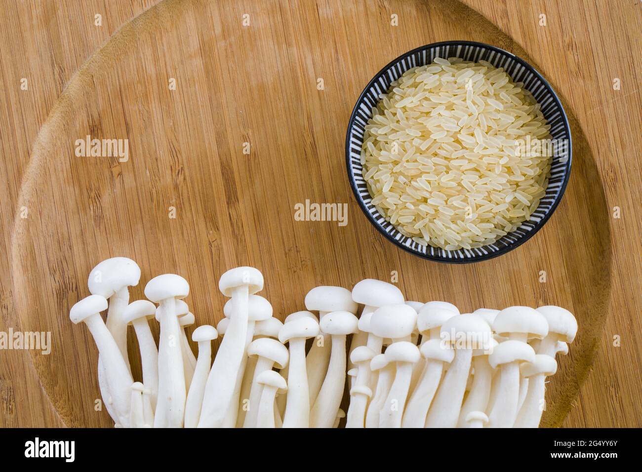 Top view of white Asian Enoki mushroom and rice served on a wooden ...