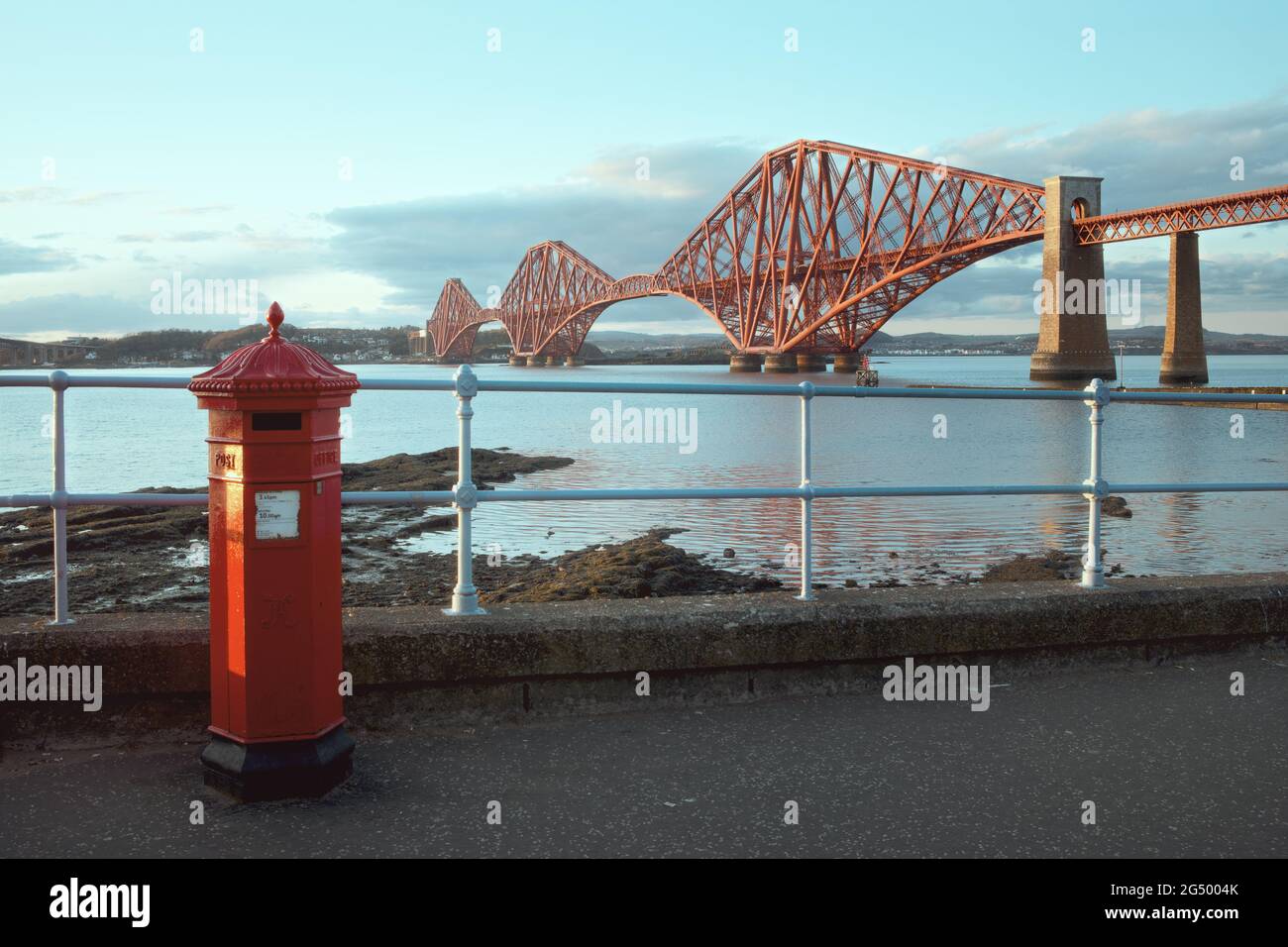 A red vintage British post box in front of the iconic Forth Rail Bridge ...