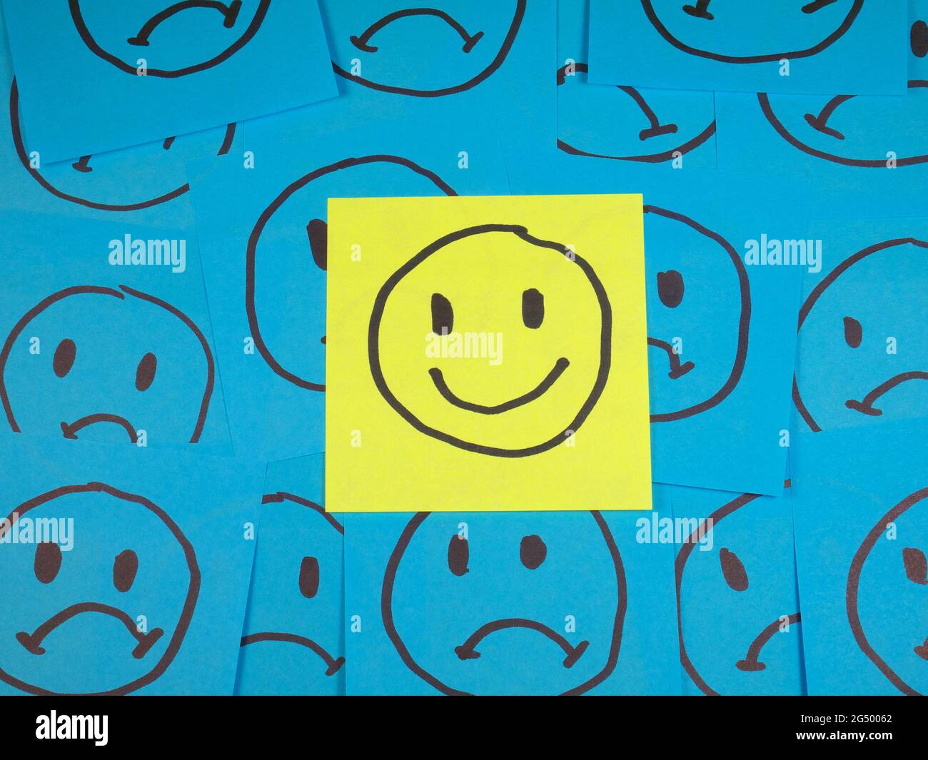 Positive smiley face on sticky note over sad faces Stock Photo - Alamy