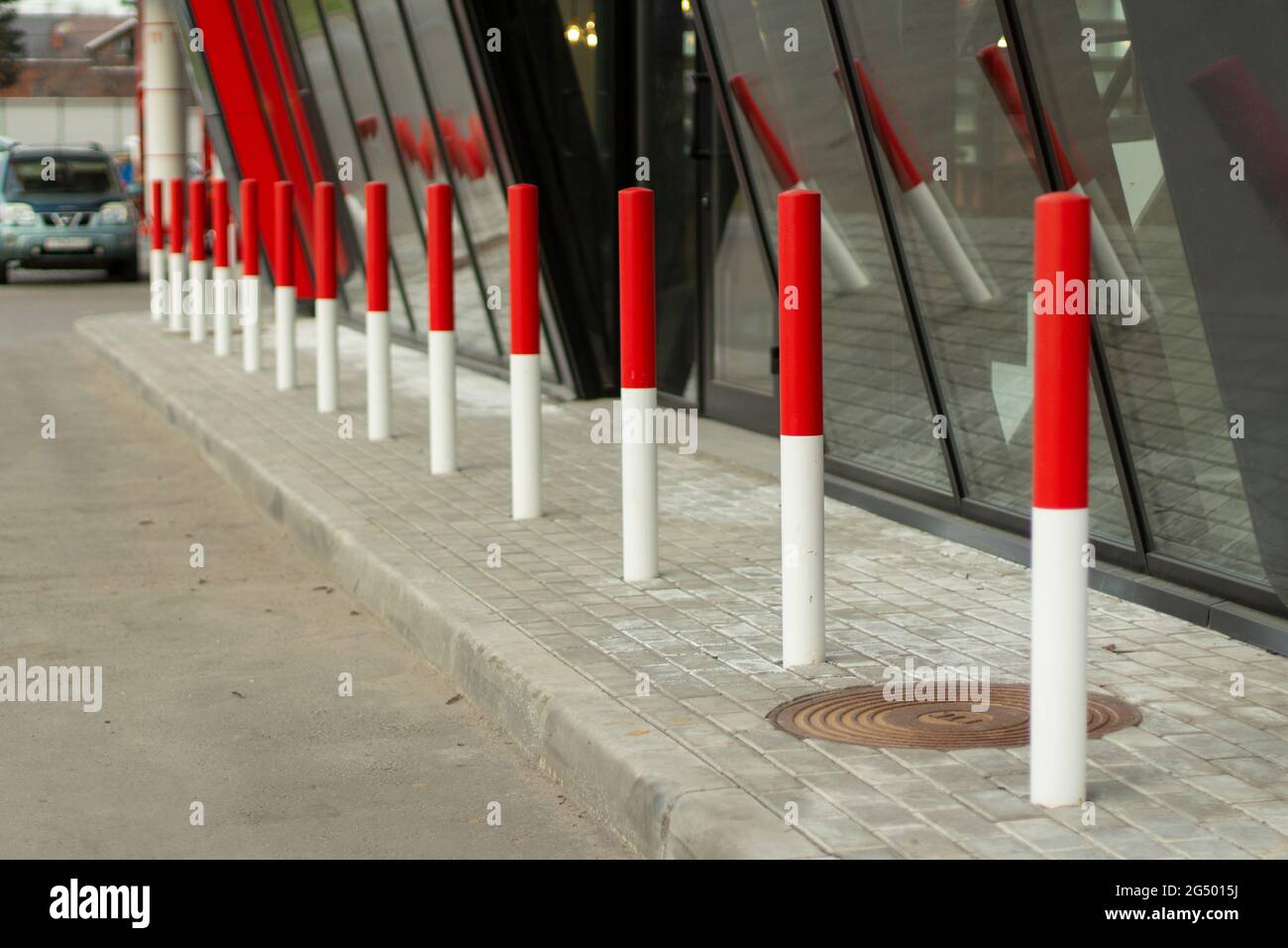 Red posts in the parking lot. Car traffic limiters. Red-white pillars ...