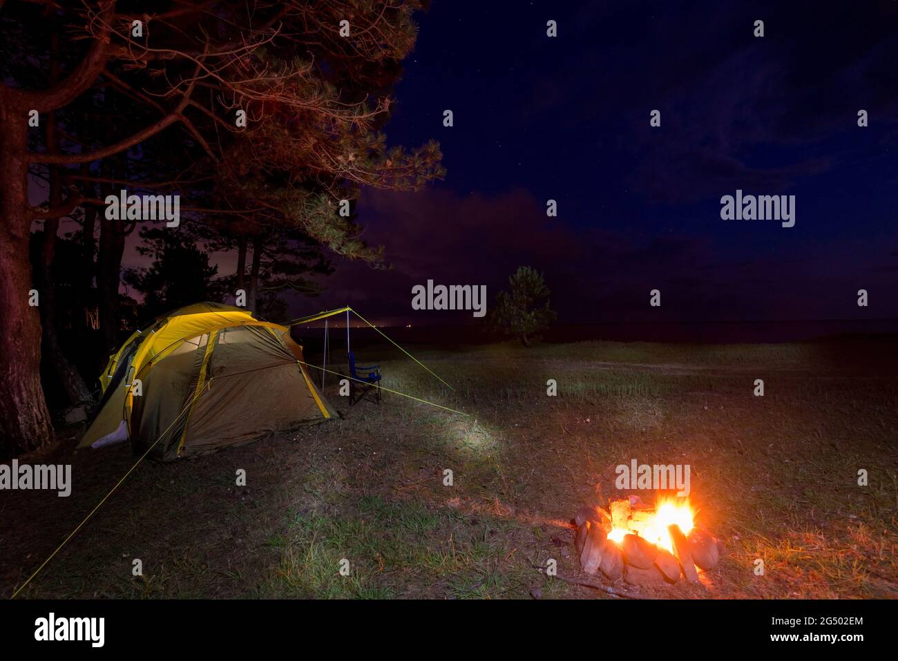 camping tent and bonfire by the sea at night Stock Photo - Alamy