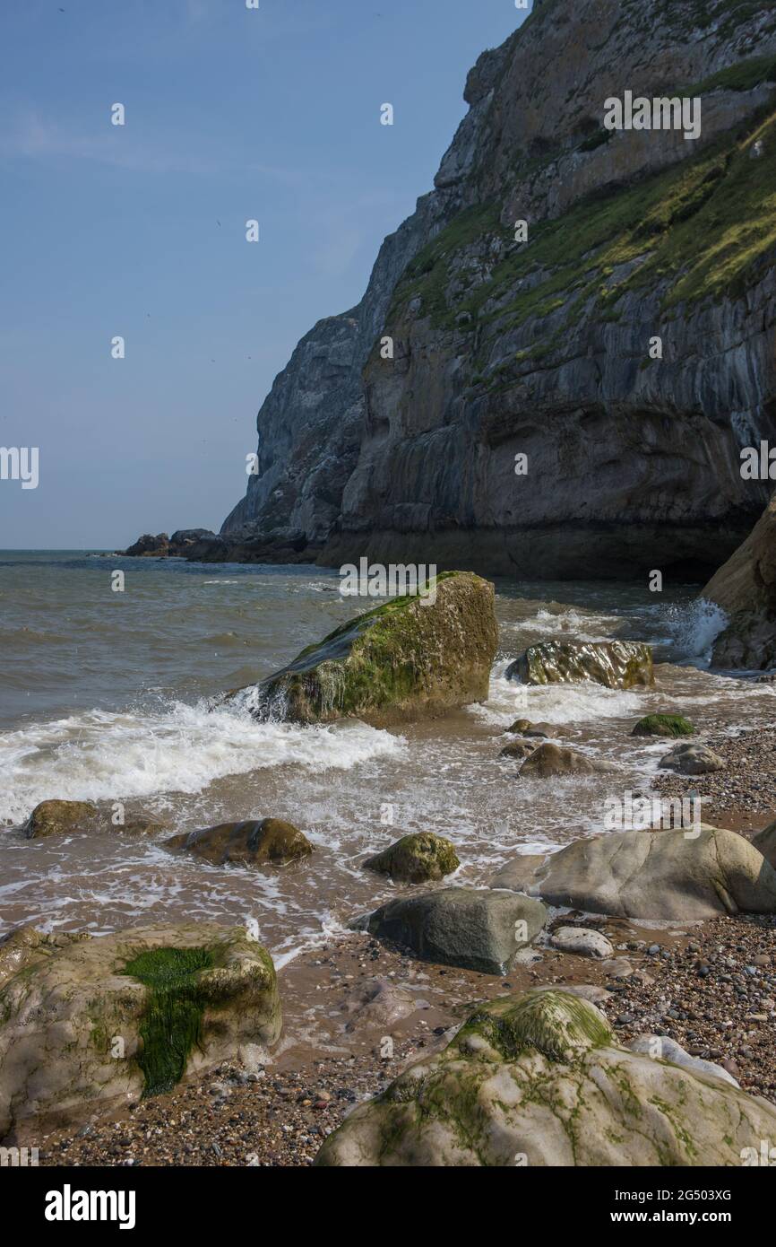 Wave splashing on the rocks at the base of the little Orme, Llandudno ...