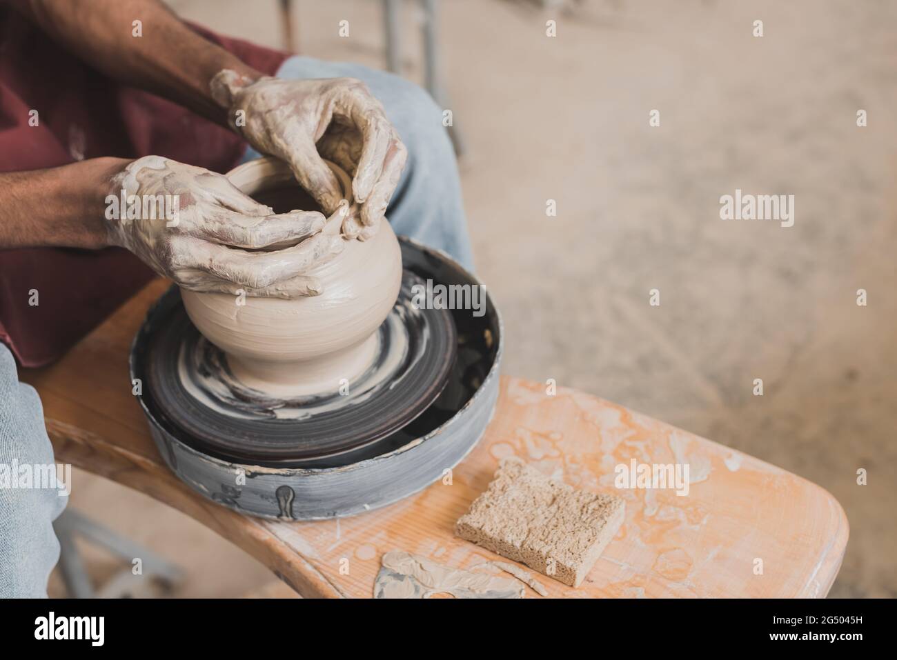 partial view of male african american hands shaping wet clay pot on ...