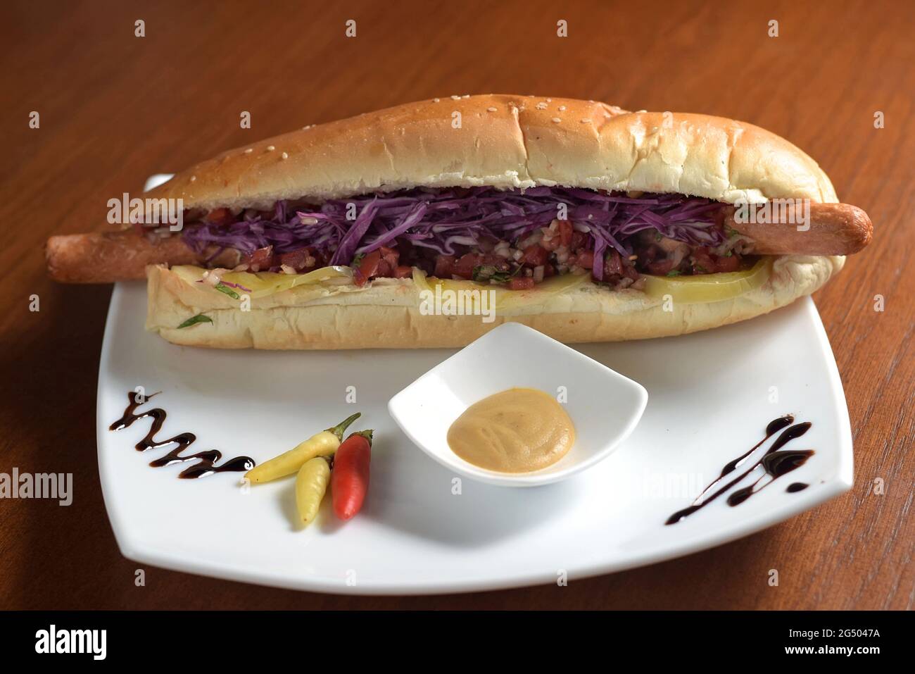 Long hot dog with two sausages, with cabbage and tomatoes, and with ...