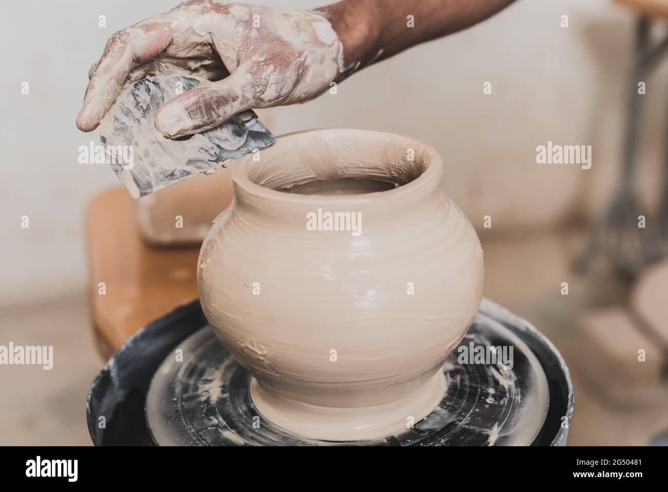 partial view of male african american hand shaping wet clay pot with ...