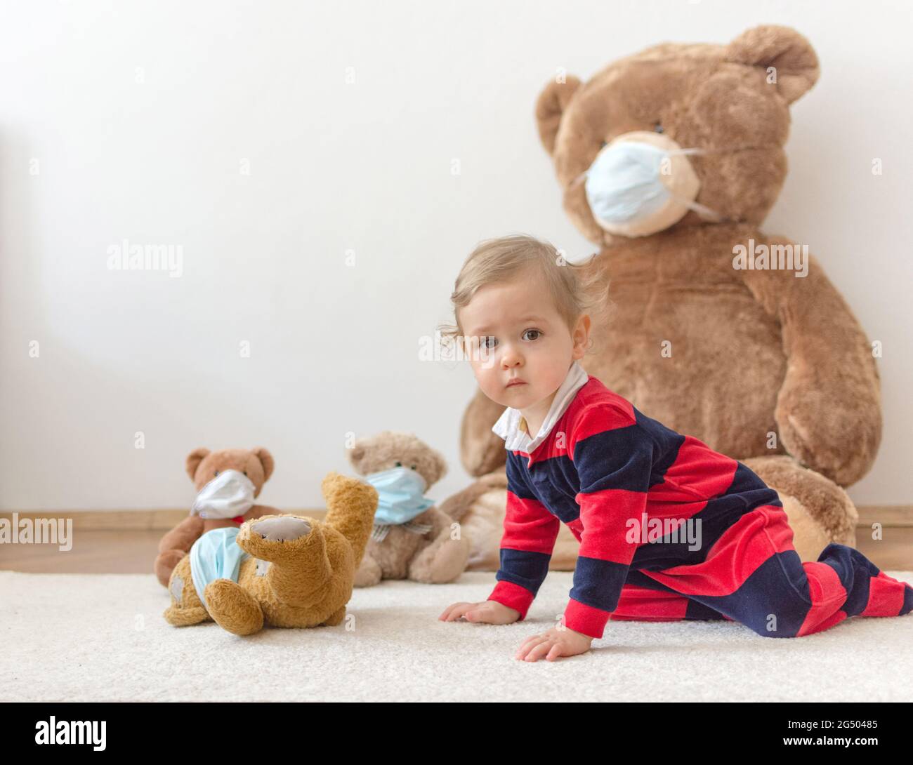 Child playing with his sick teddy bears wearing medical mask against ...