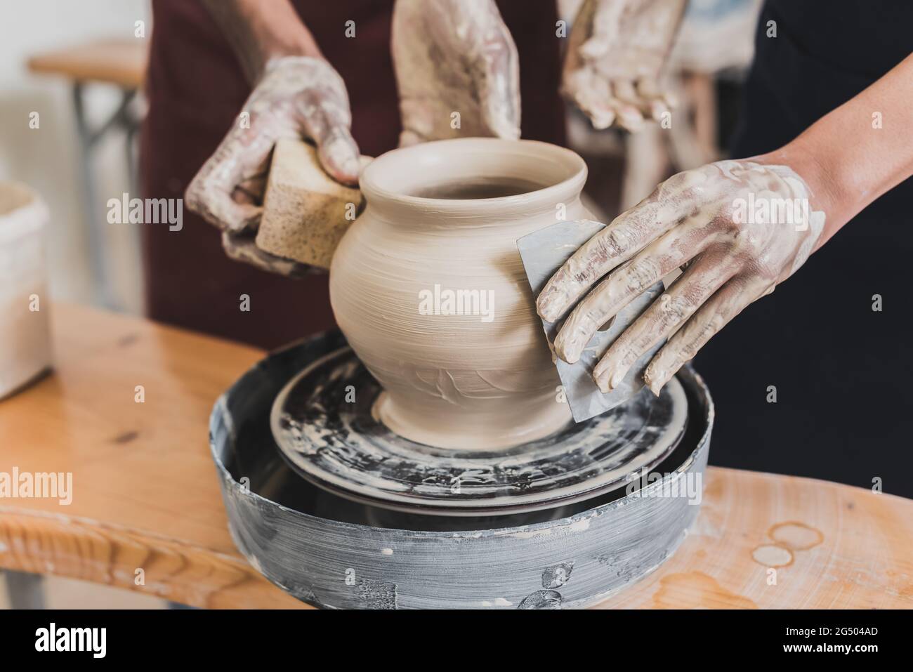 partial view of young african american couple shaping wet clay pot on ...