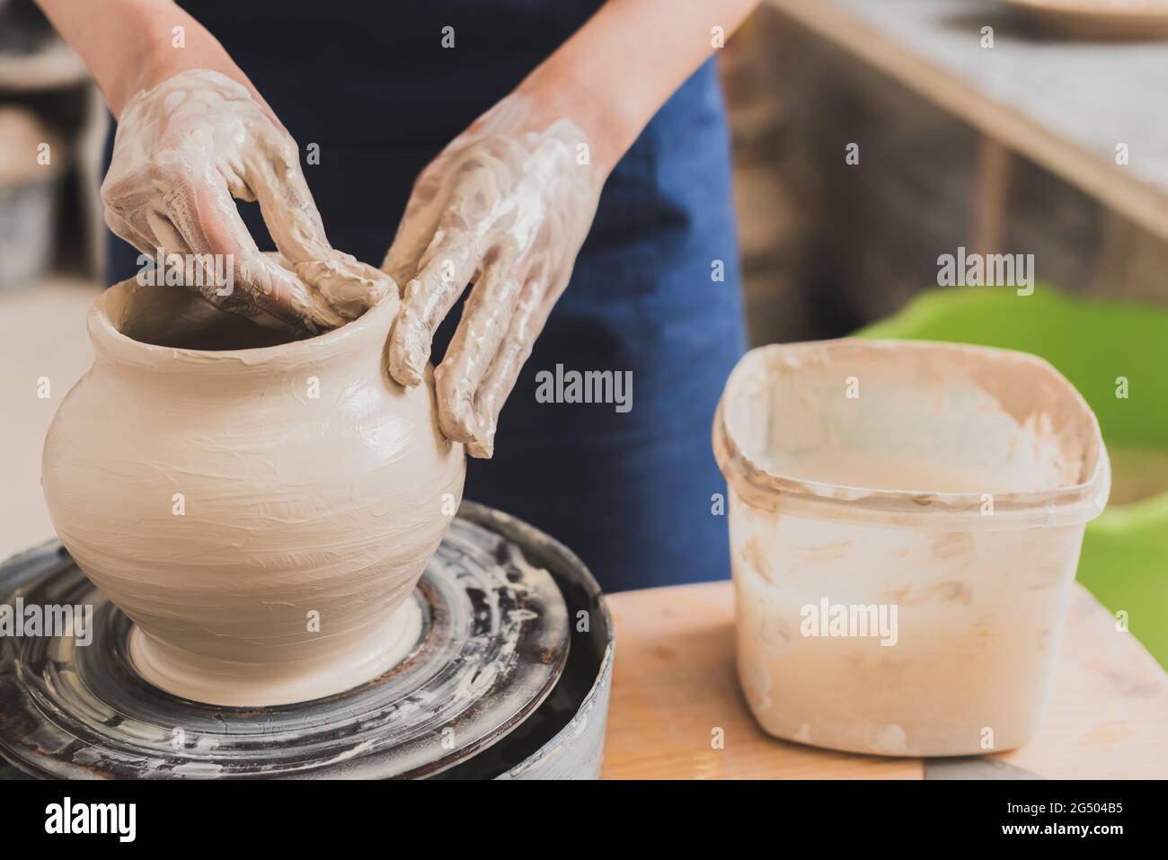 close up view of young african american woman shaping wet clay pot on ...