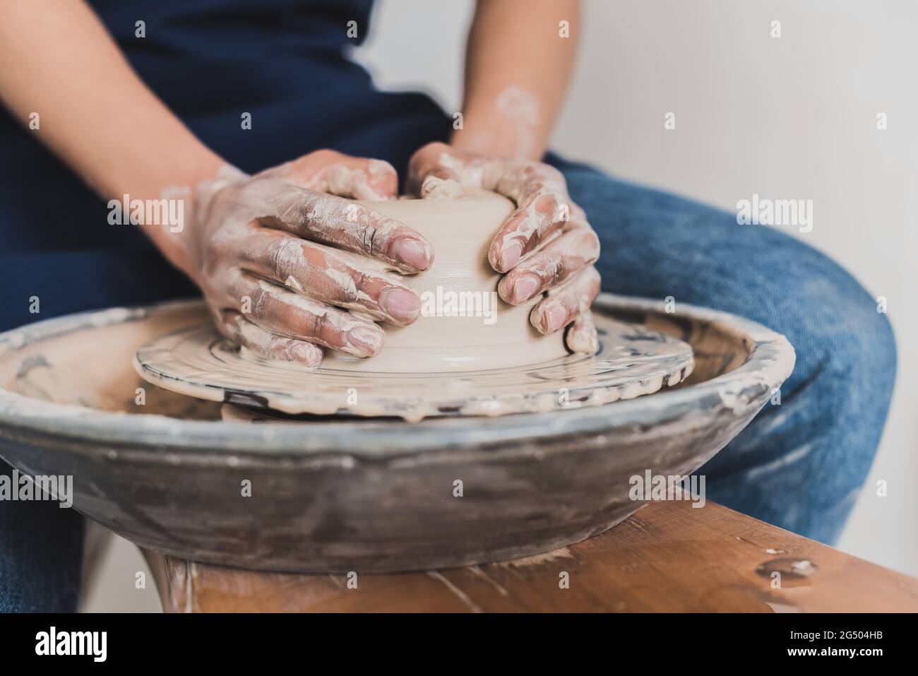 partial view of young african american woman modeling wet clay on wheel ...
