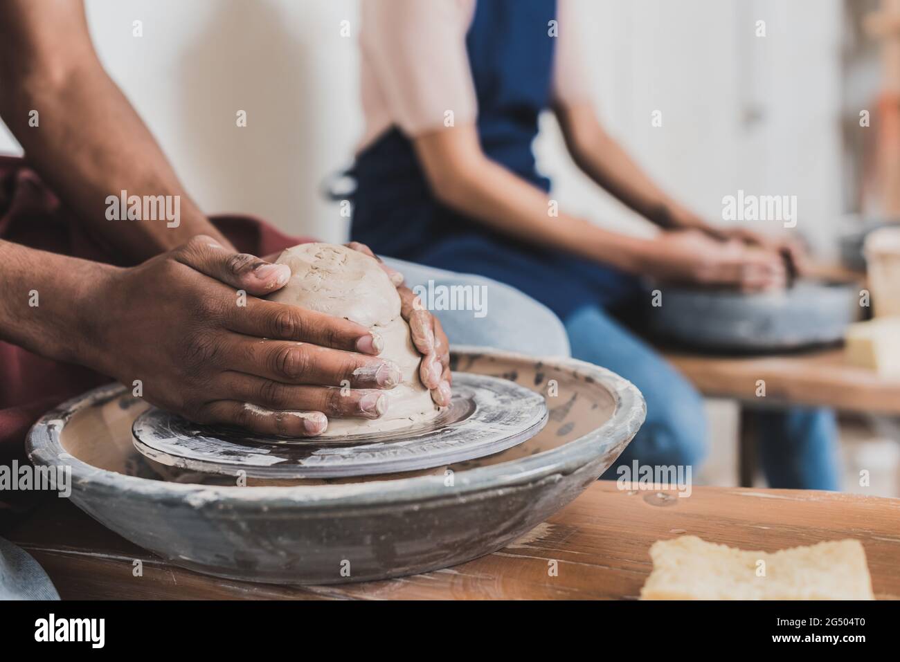 partial view of young african american couple modeling wet clay on ...